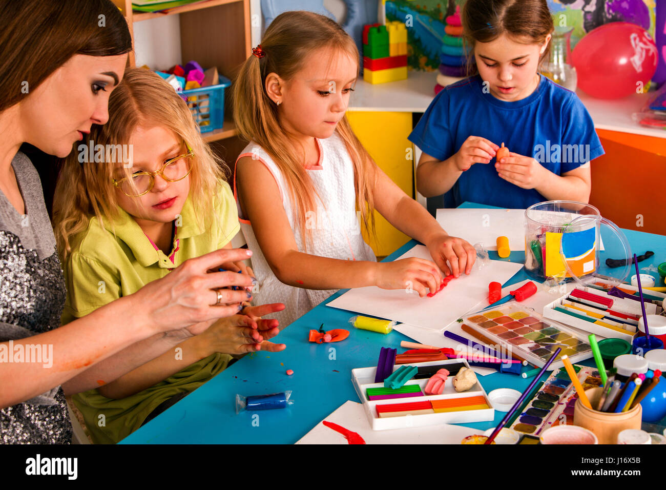 Plasticine modeling clay in children class. Teacher teaches in school ...