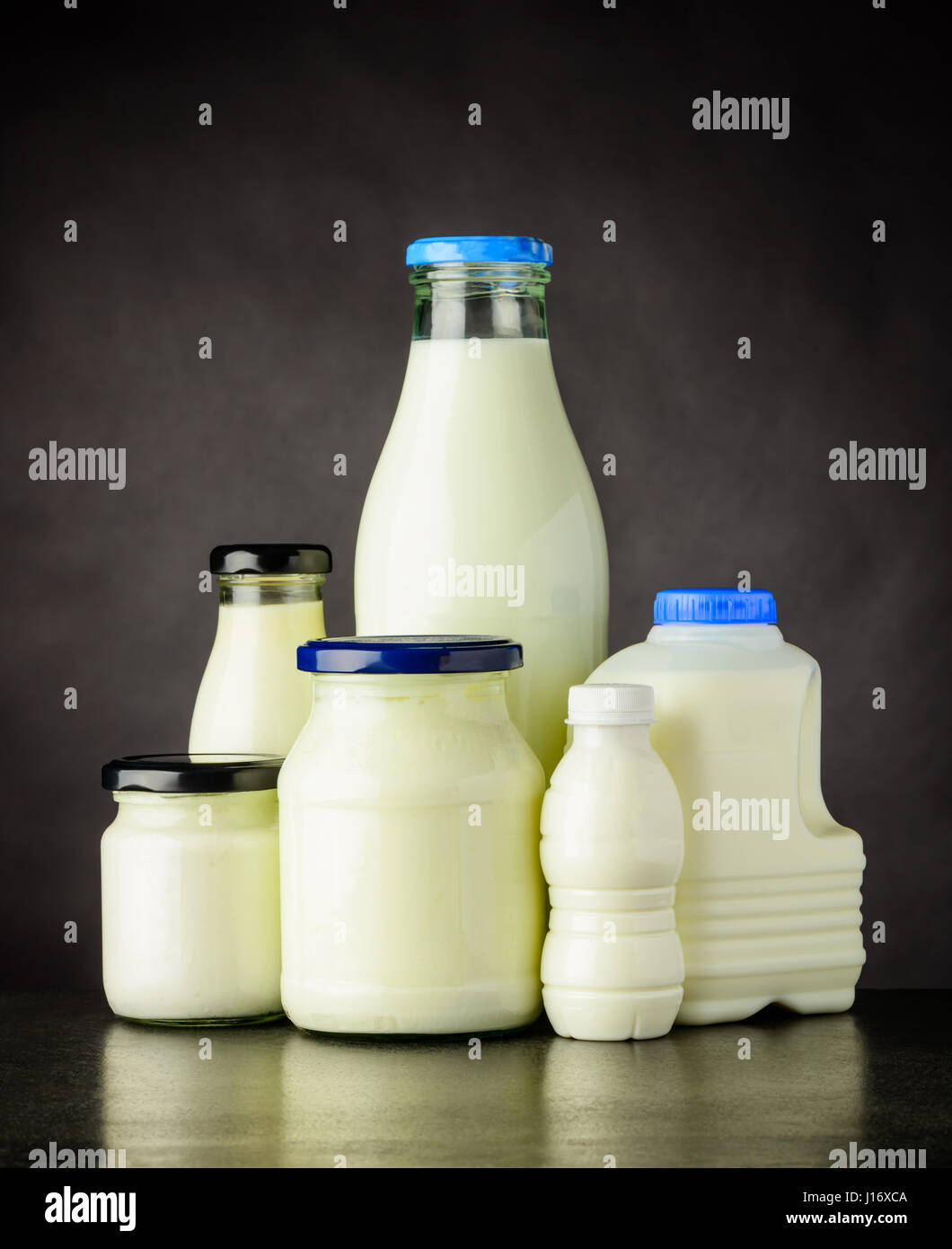 Bottles and Jars of Different Types of Milk Products on Dark Background ...