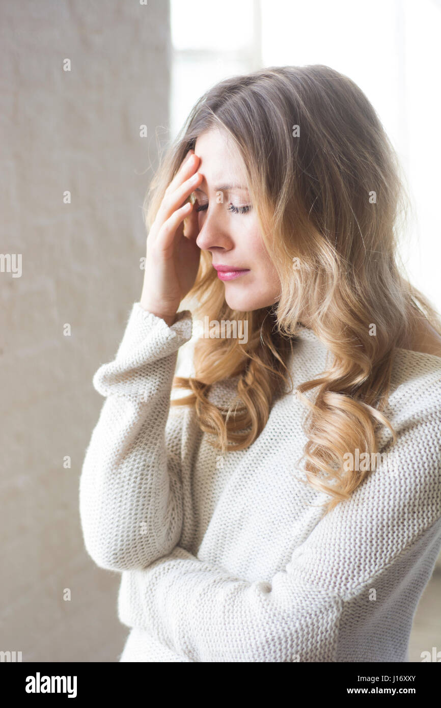 Sad young woman hand on head Stock Photo - Alamy
