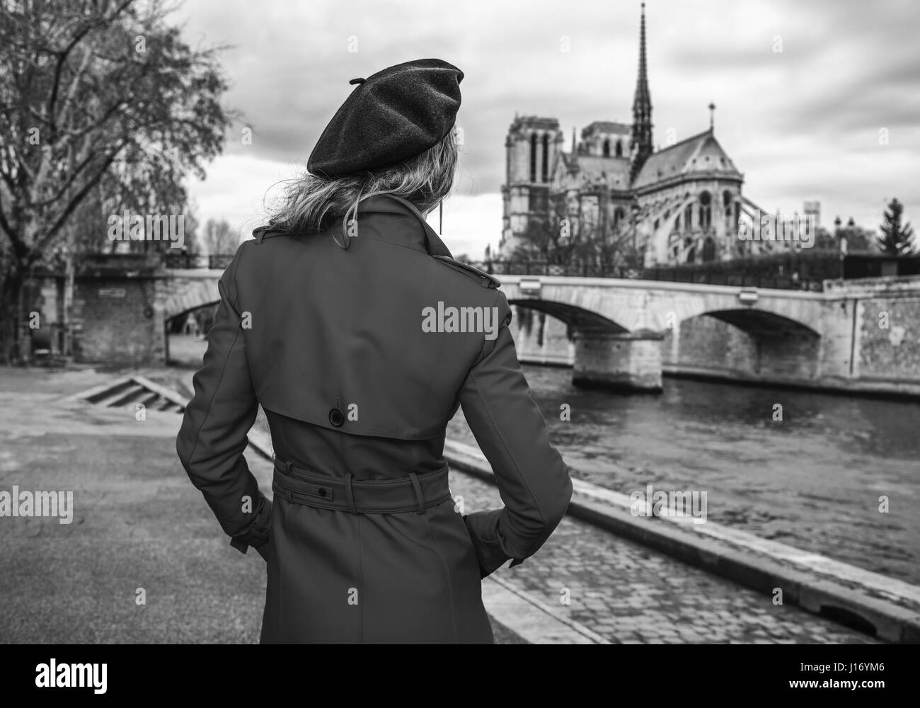 Bright in Paris. Seen from behind trendy traveller woman in red trench ...