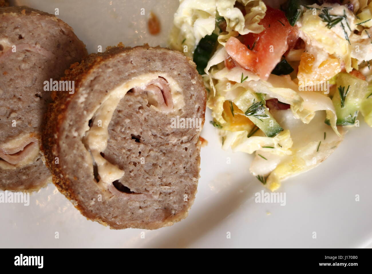 Meat roulade with salad on plate. Rolled meat with a filling of cheese ...