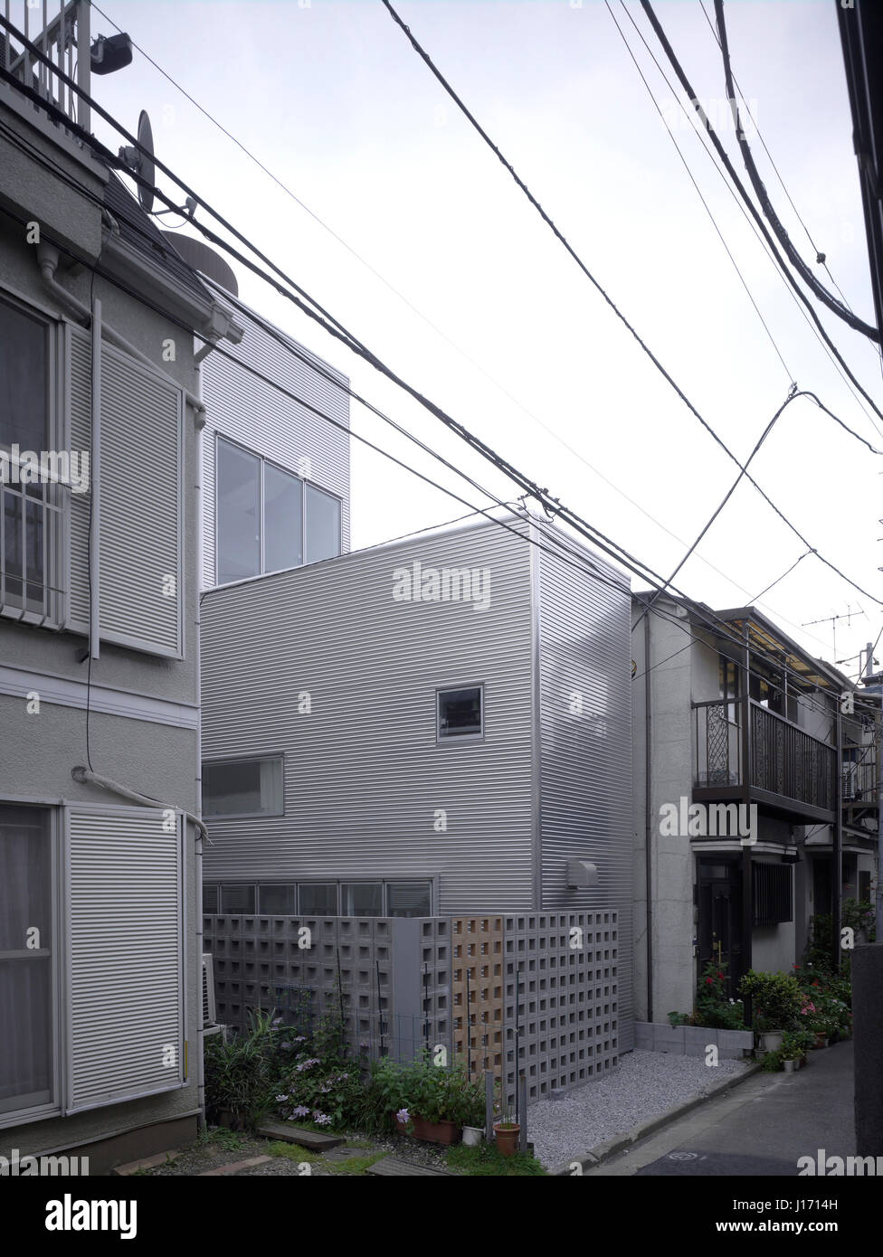 Street view with compact house clad in metal sheeting. Townhouse in ...