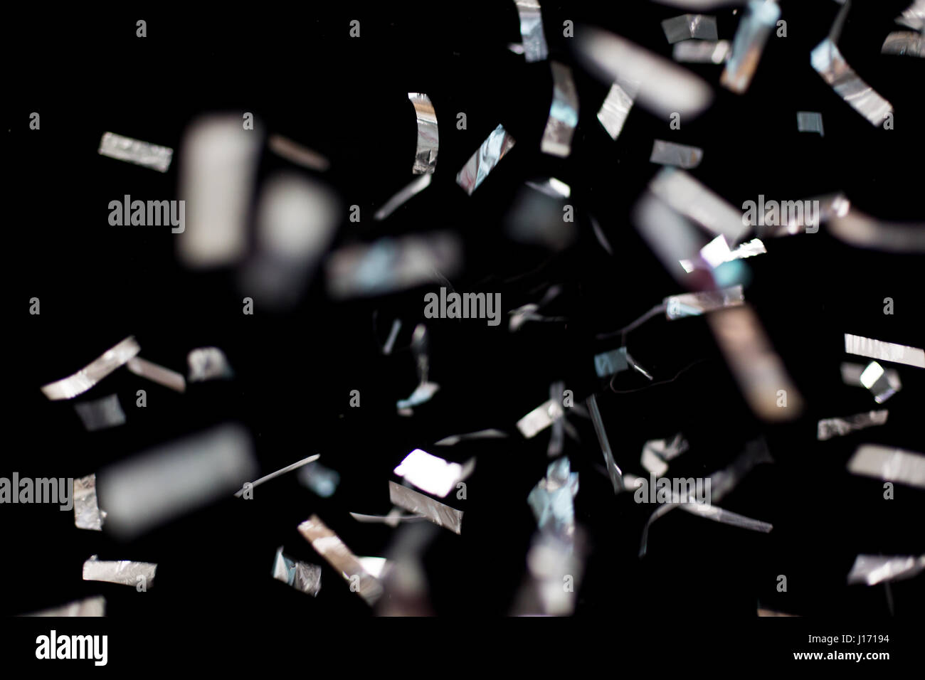 silver confetti over black background Stock Photo - Alamy