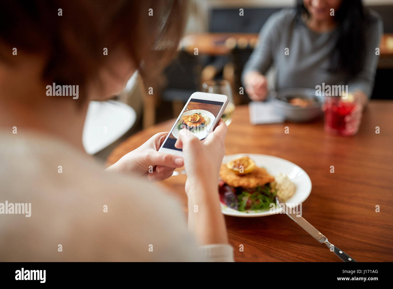 women with smartphones and food at restaurant Stock Photo - Alamy