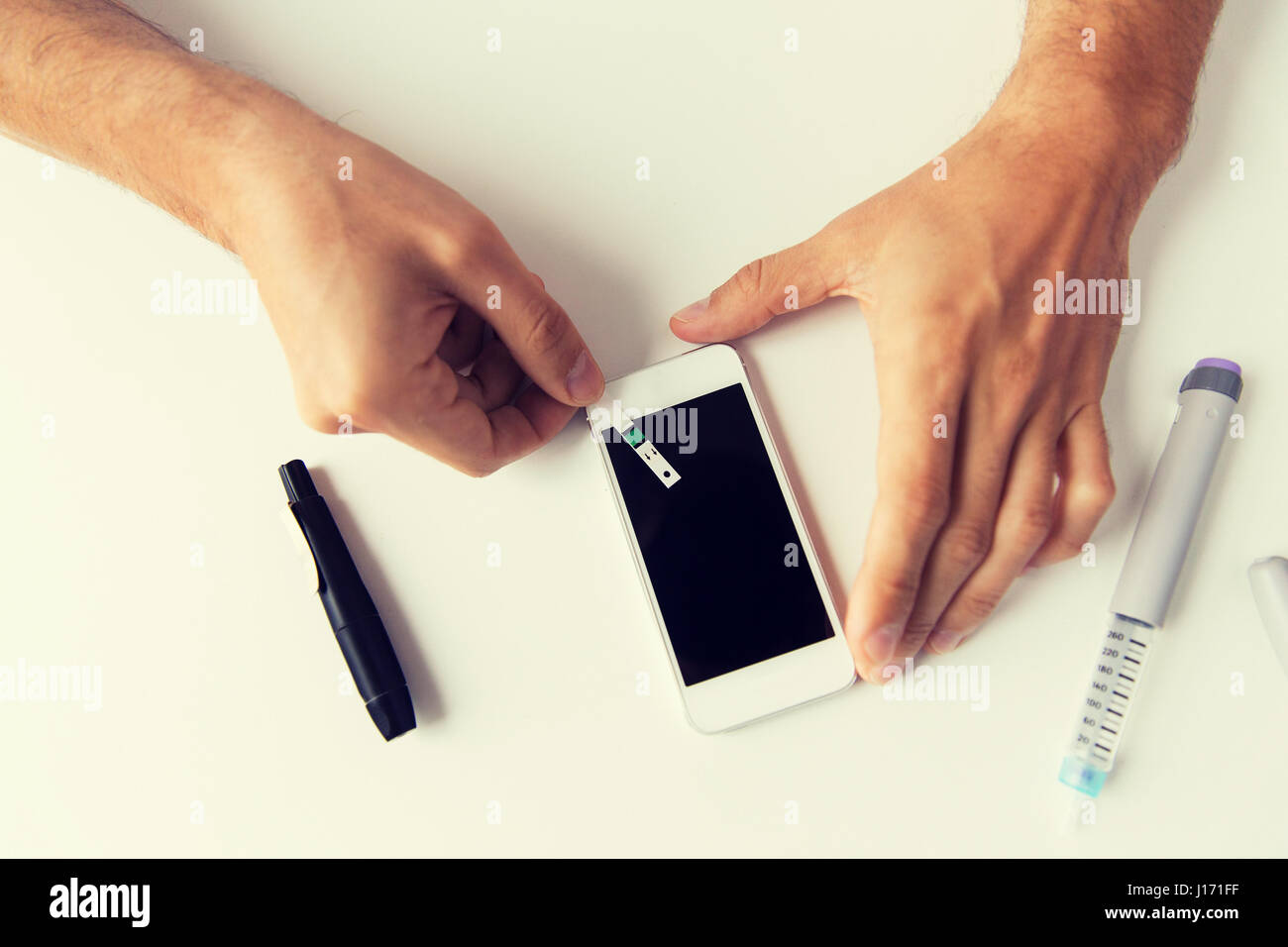 close up of man with smartphone making blood test Stock Photo - Alamy