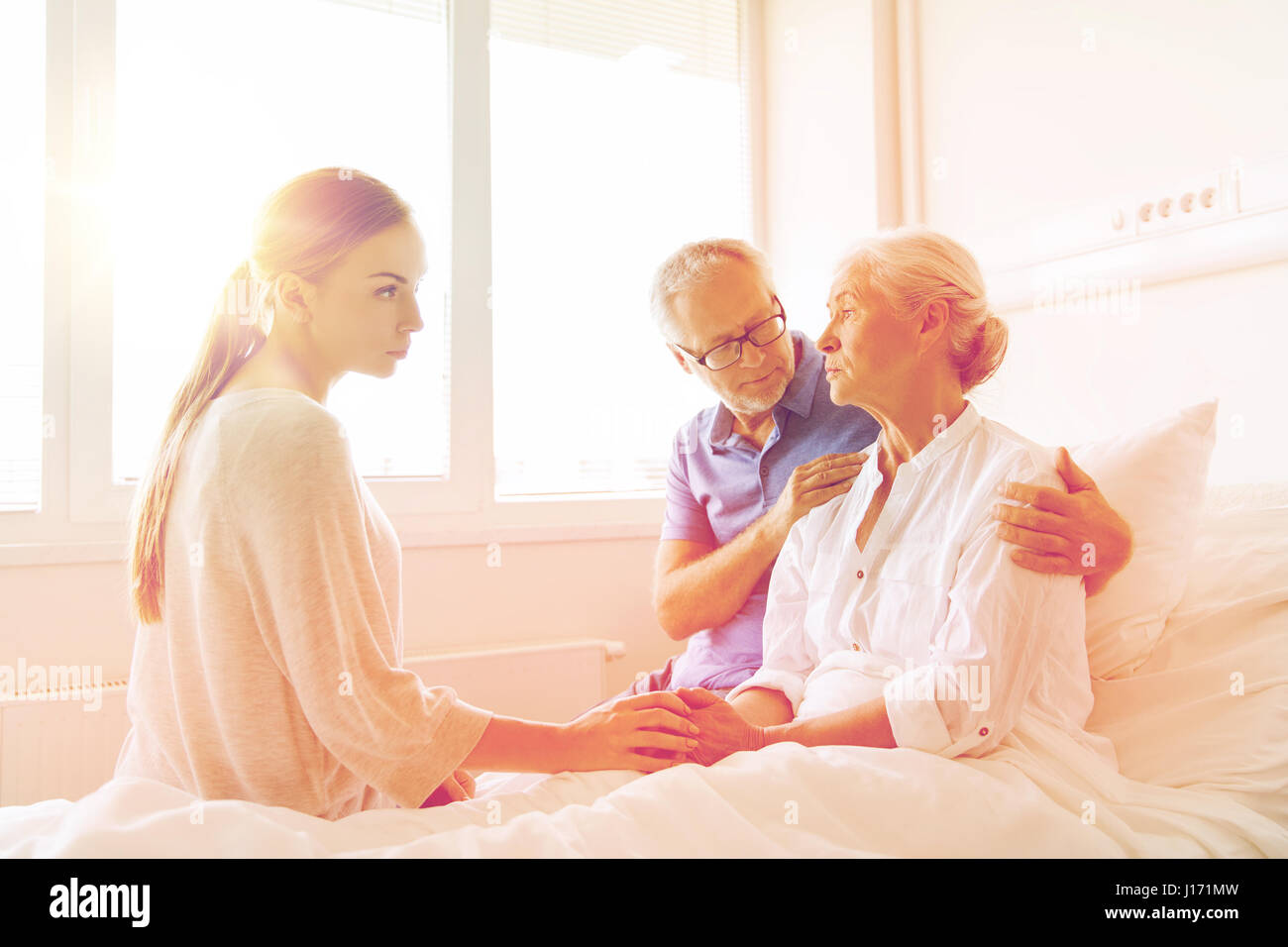 family visiting ill senior woman at hospital Stock Photo - Alamy
