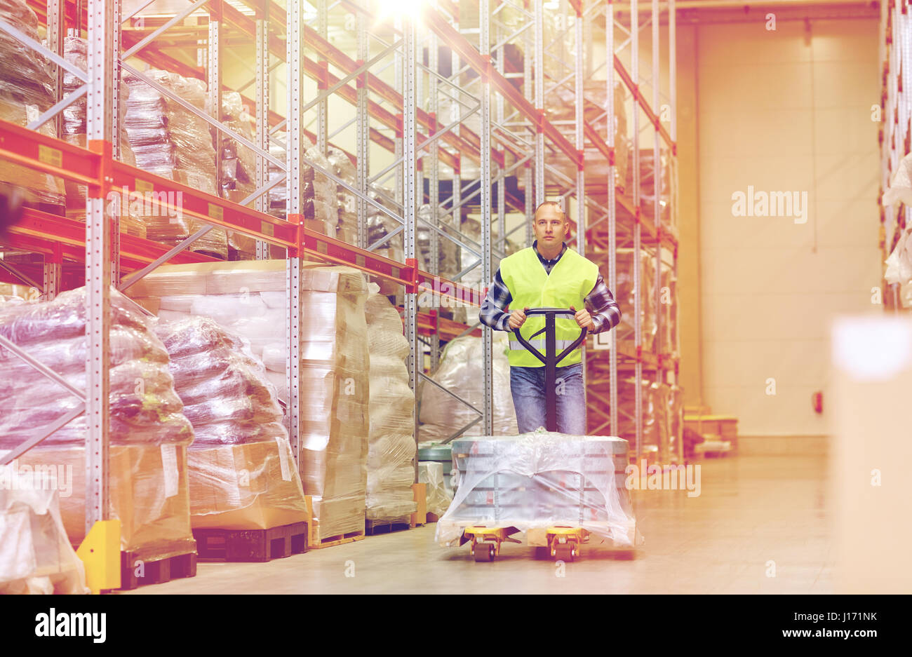 man carrying loader with goods at warehouse Stock Photo - Alamy