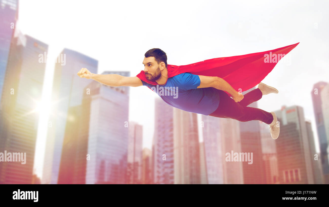 man in red superhero cape flying over city Stock Photo - Alamy