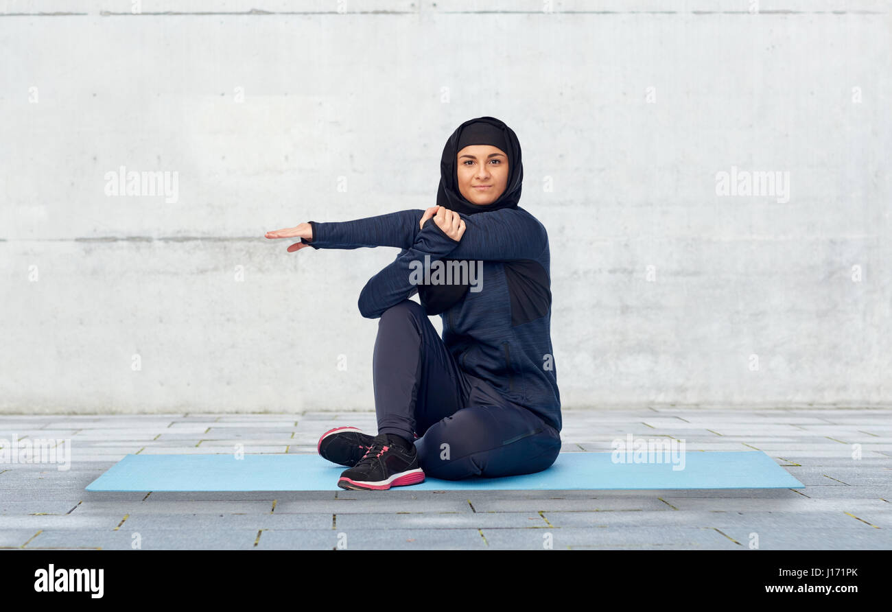 muslim woman doing sportand stretching on mat Stock Photo - Alamy