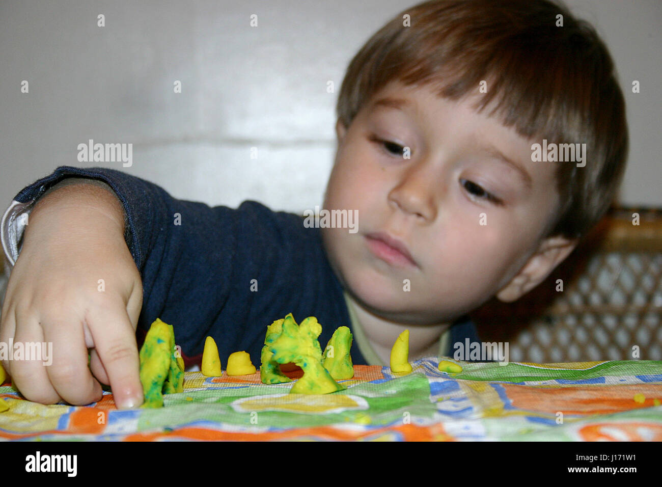 Little boy playing with playdough Stock Photo - Alamy