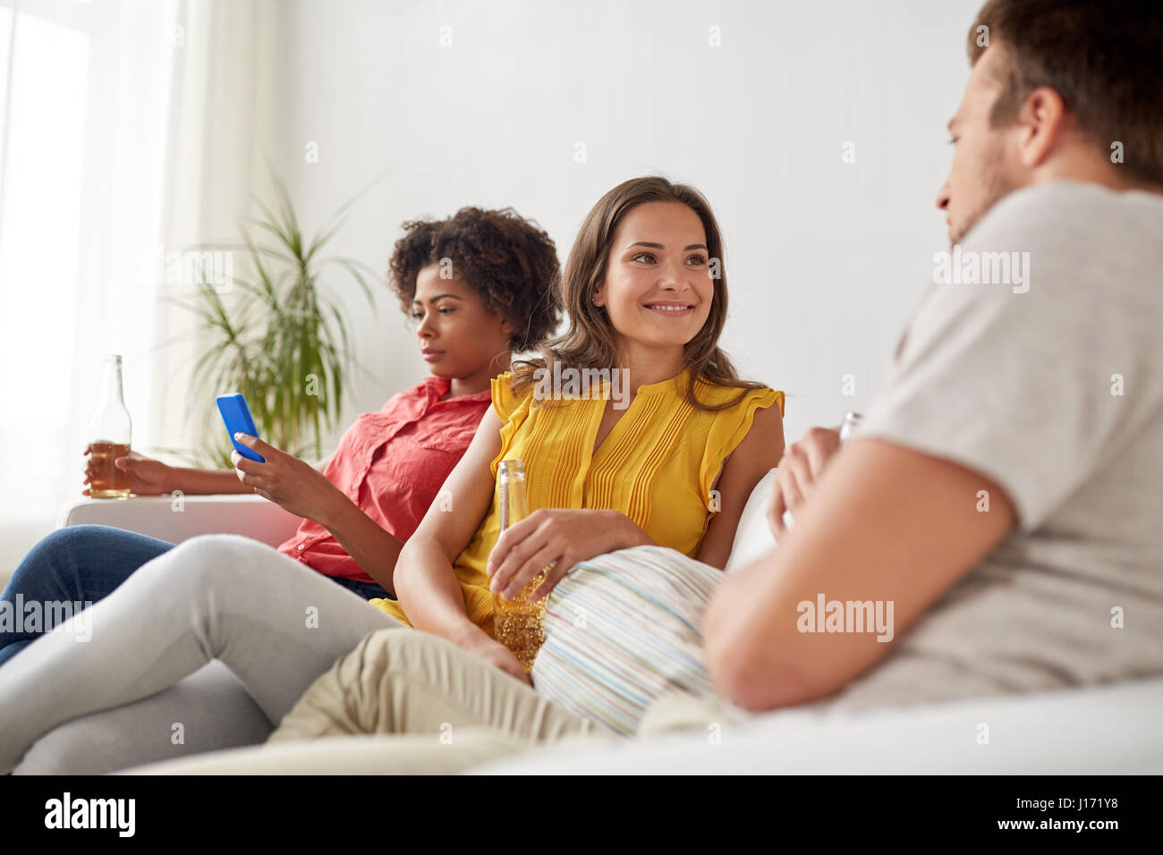 group of happy friends with beer talking at home Stock Photo - Alamy