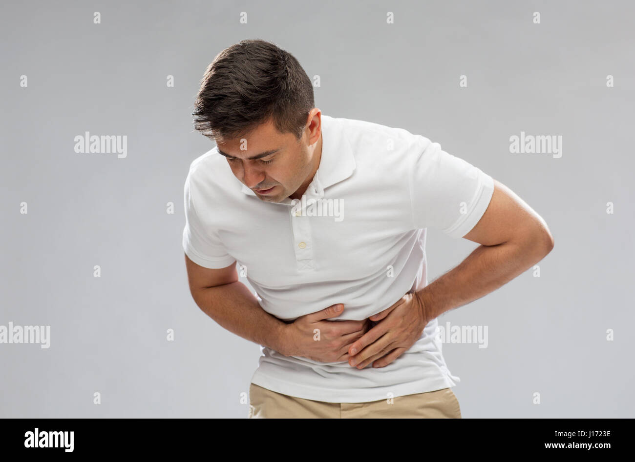 unhappy man suffering from stomach ache Stock Photo - Alamy