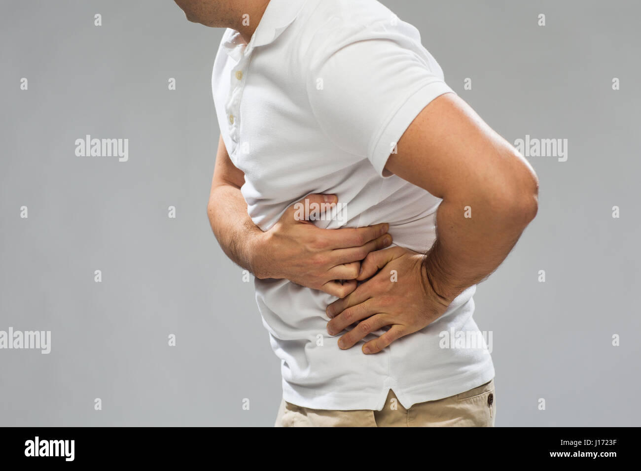 close up of man suffering from pain in side Stock Photo - Alamy