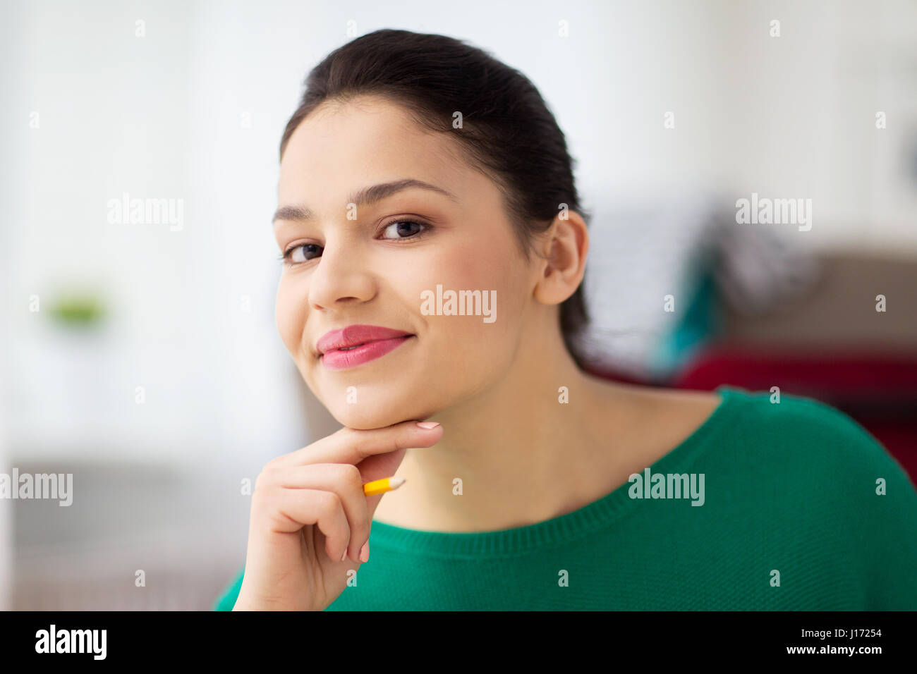 happy young woman with pencil thinking Stock Photo - Alamy