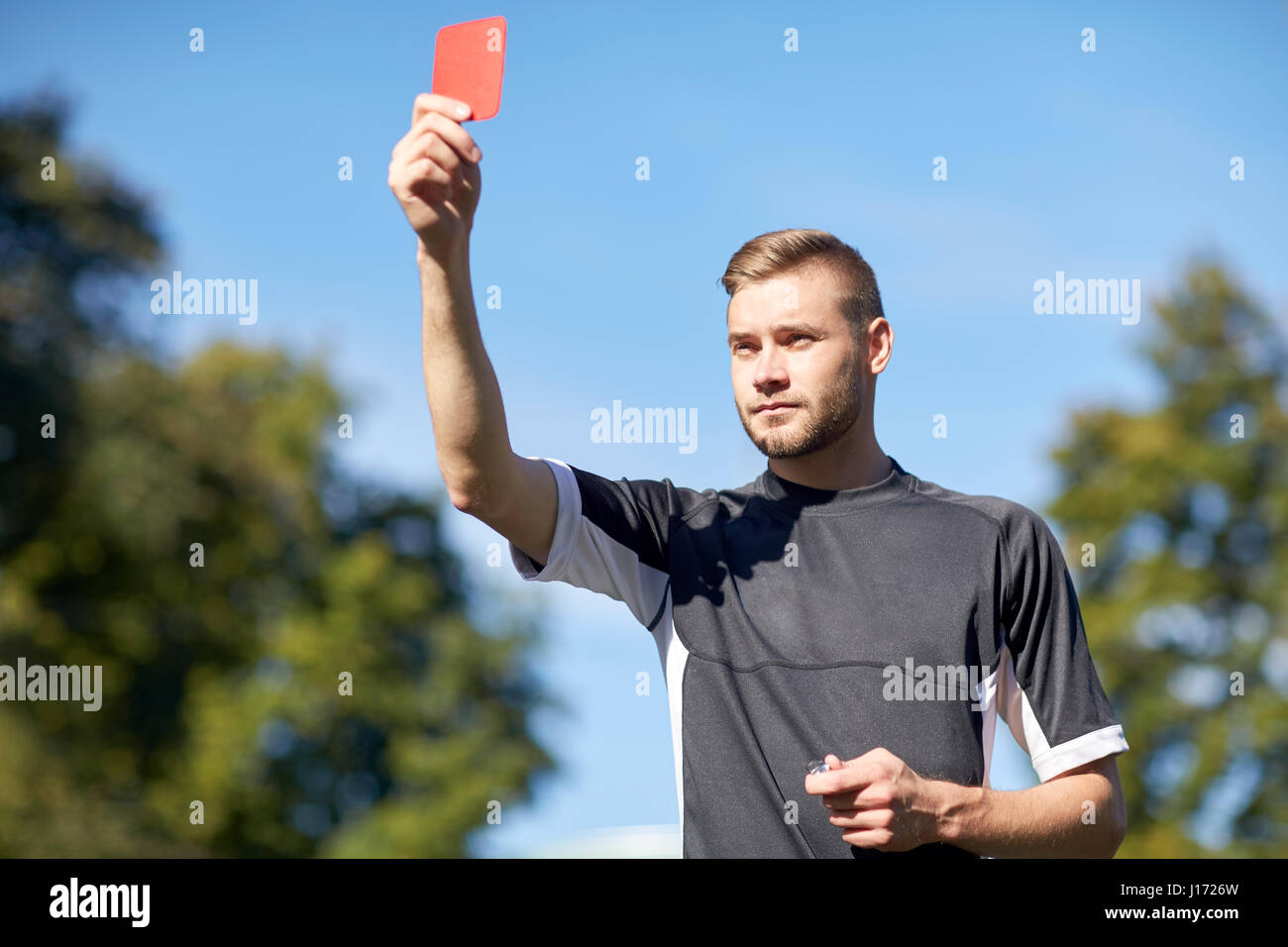 referee on football field showing yellow card Stock Photo - Alamy