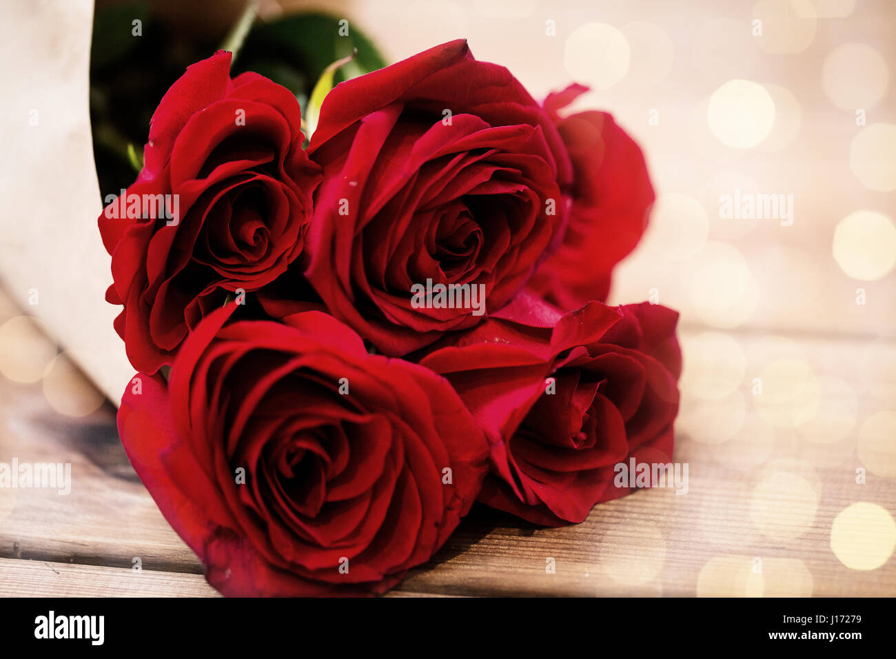 close up of red roses bunch wrapped into paper Stock Photo - Alamy