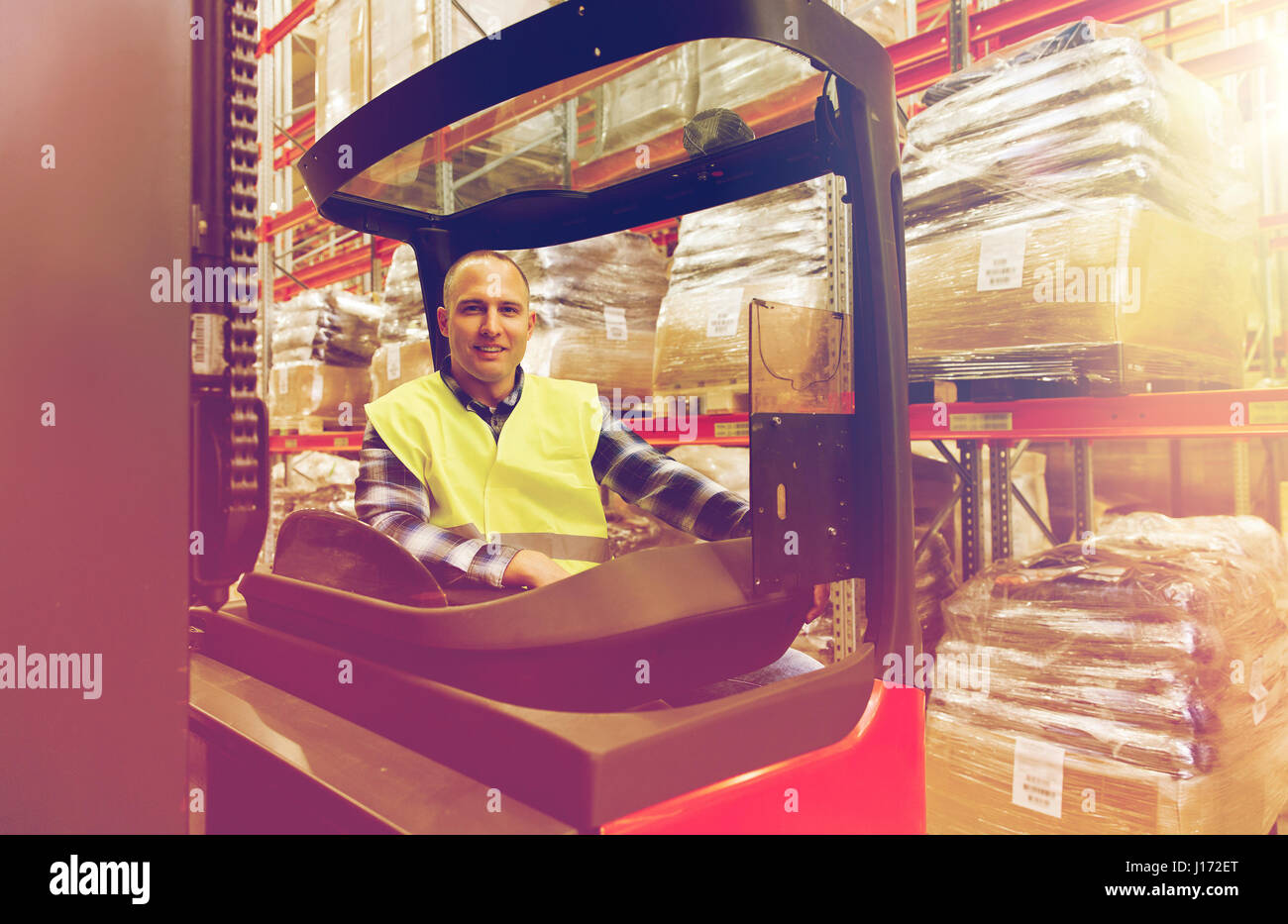smiling man operating forklift loader at warehouse Stock Photo - Alamy