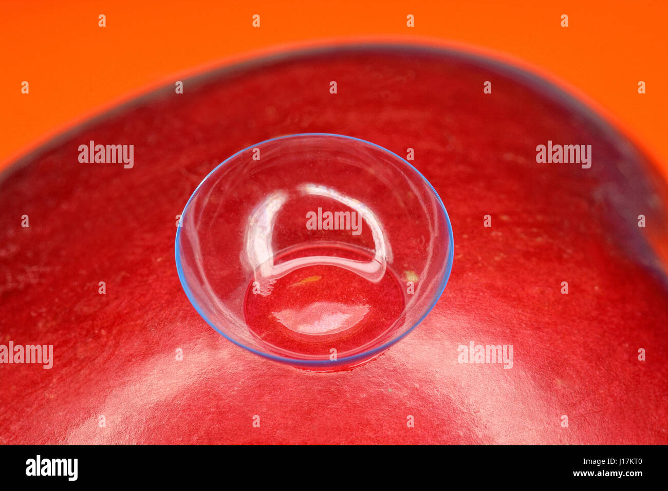 Soft contact lens on the surface of the red apple Stock Photo - Alamy