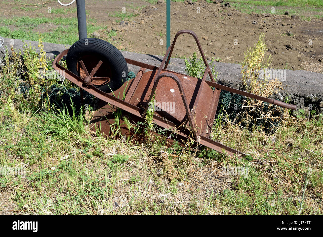 old broken and rusty wheelbarrow abandoned on a lawn Stock Photo - Alamy