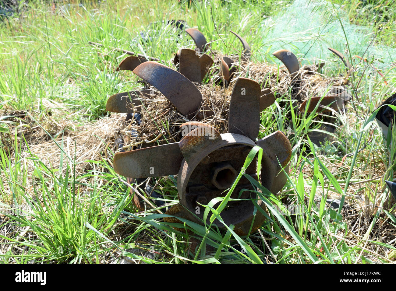 cutters of an old rotary tiller full of weeds Stock Photo - Alamy