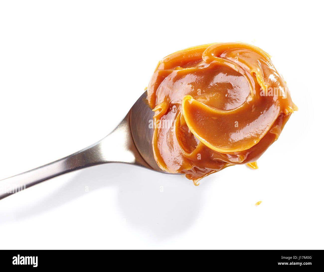 spoon of soft homemade caramel isolated on white background, top view ...