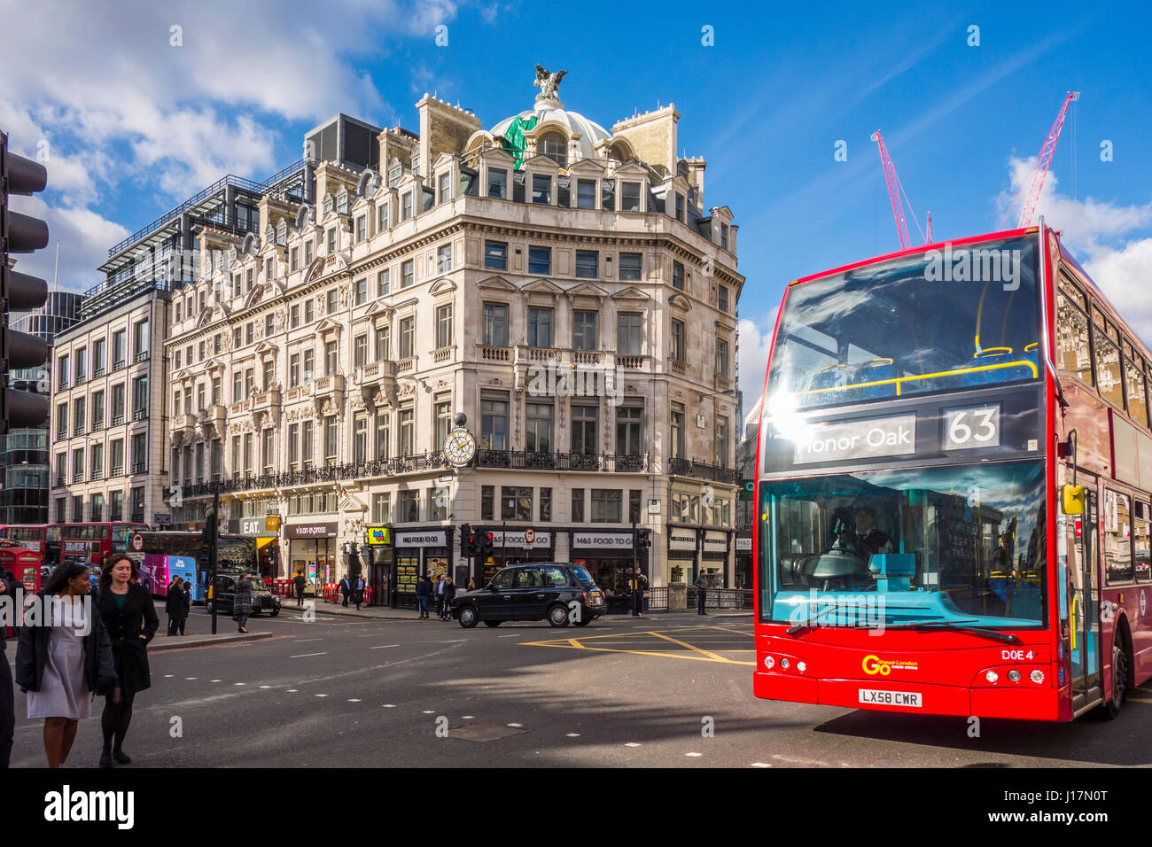 Red London bus driving accross Ludgate Circus in the City of London, UK ...