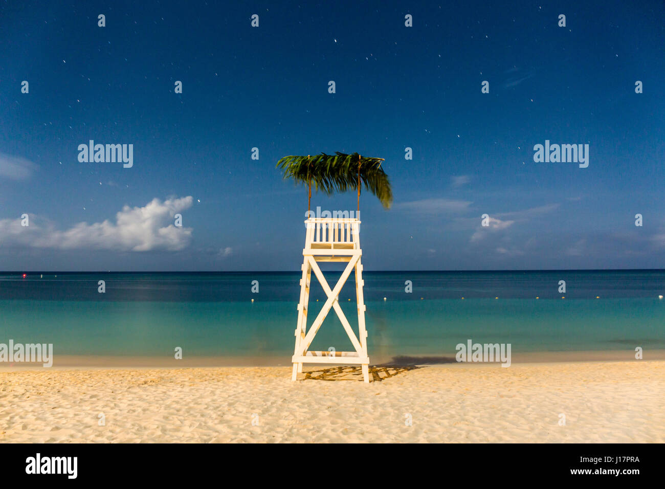 A full moon lights upa lifeguard perch on the beach in West Bay, Roatan ...