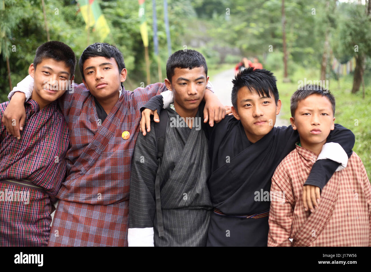 Bhutanese boys in traditional dress the gho, a knee-length robe tied ...