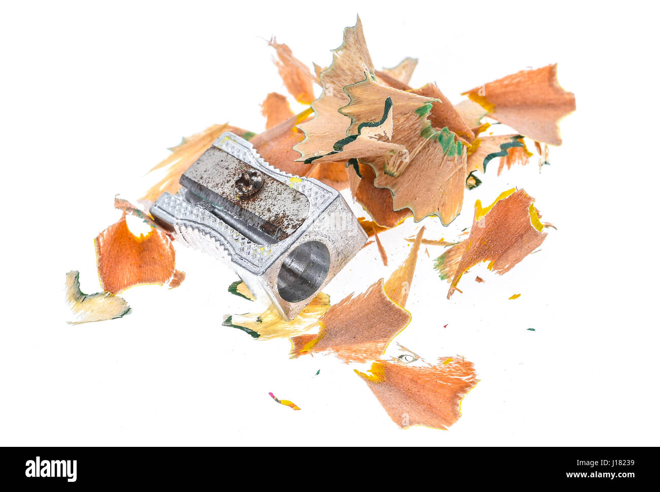 Old rusty metal pencil sharpener and different colour shavings. Close ...