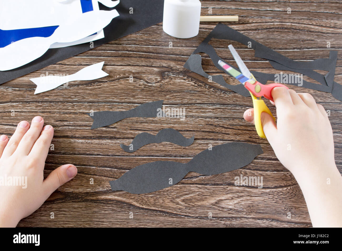 The child cuts out paper parts. Greeting card for Father's Day. Made by ...