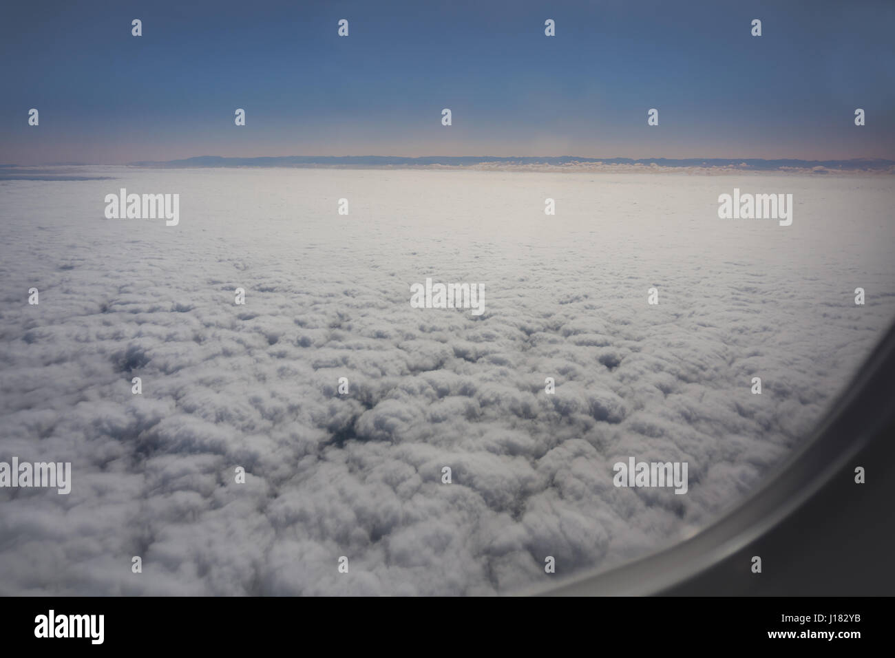 Blue sky, clouds with pink horizon through plane window Stock Photo - Alamy
