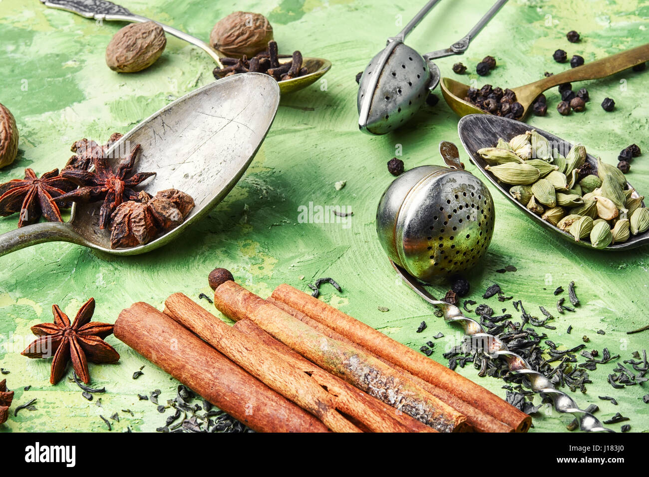spices and ingredients for Indian masala tea on green background Stock ...