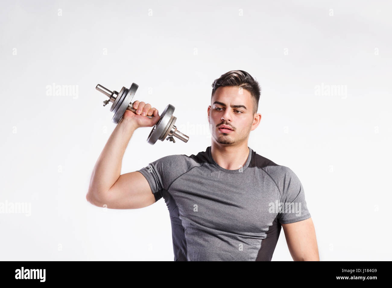 Fitness man holding dumbbell, working out, studio shot Stock Photo - Alamy
