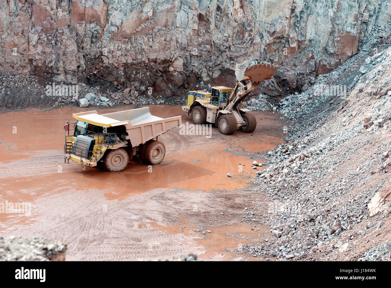 quarry mine of porphyry rock. earthmover loading a dumper truck Stock ...