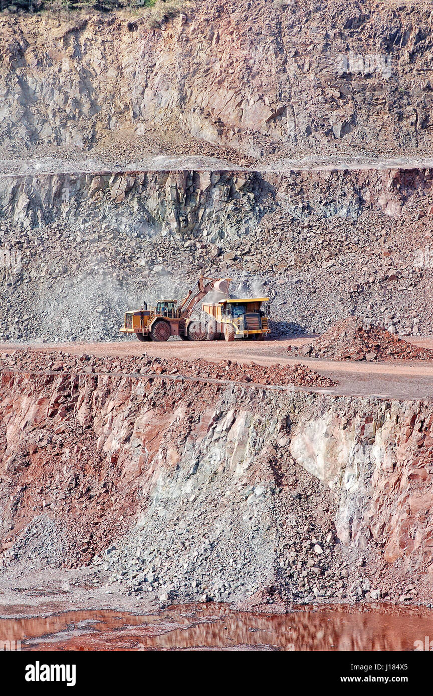quarry mine of porphyry rock. earthmover loading a dumper truck Stock ...