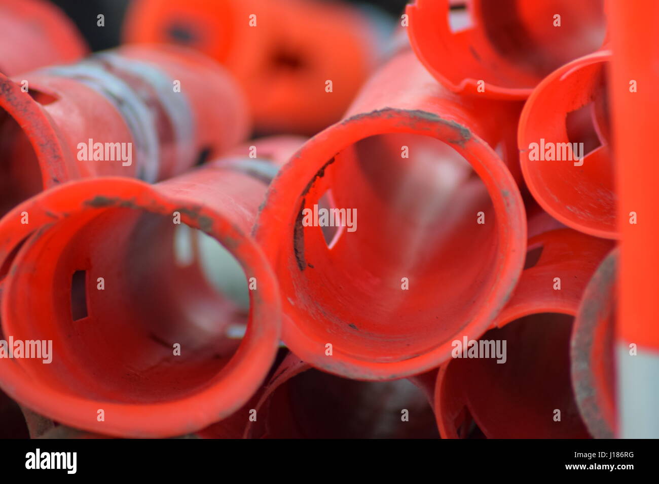 Red cylinder traffic cones stacked Stock Photo - Alamy