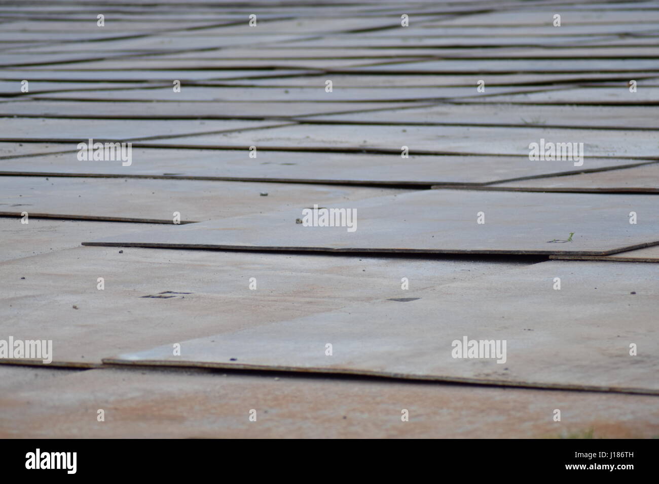 Metal plates laid out on the ground for construction work Stock Photo ...