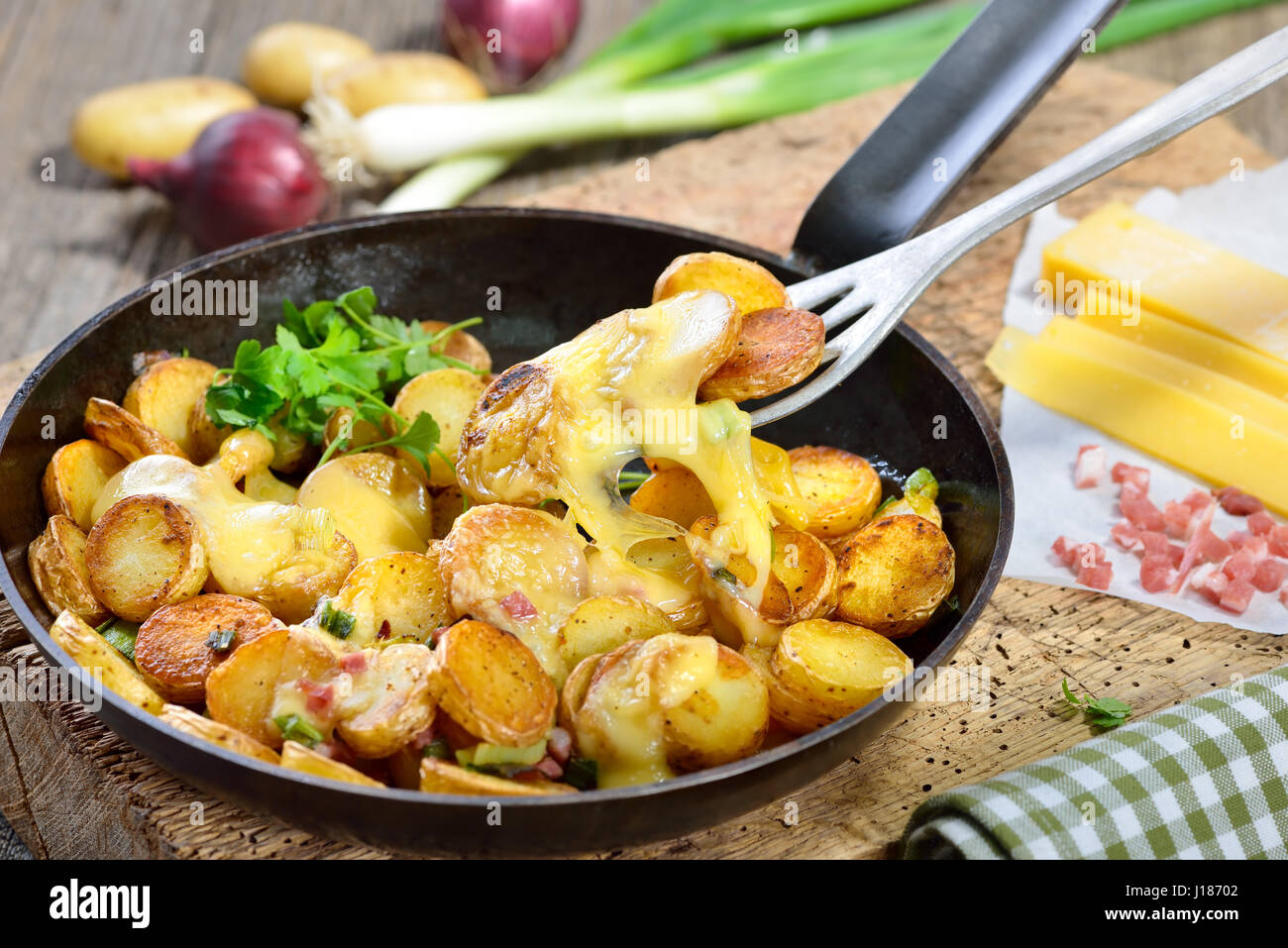 Fried unpeeled baby potatoes with melted mountain cheese and bacon ...