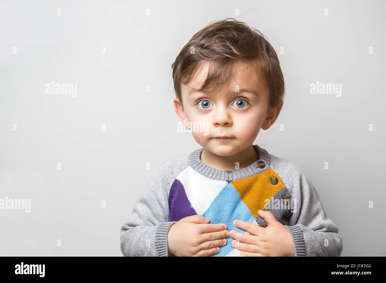 Child with his hands on the chest with a funny look Stock Photo - Alamy