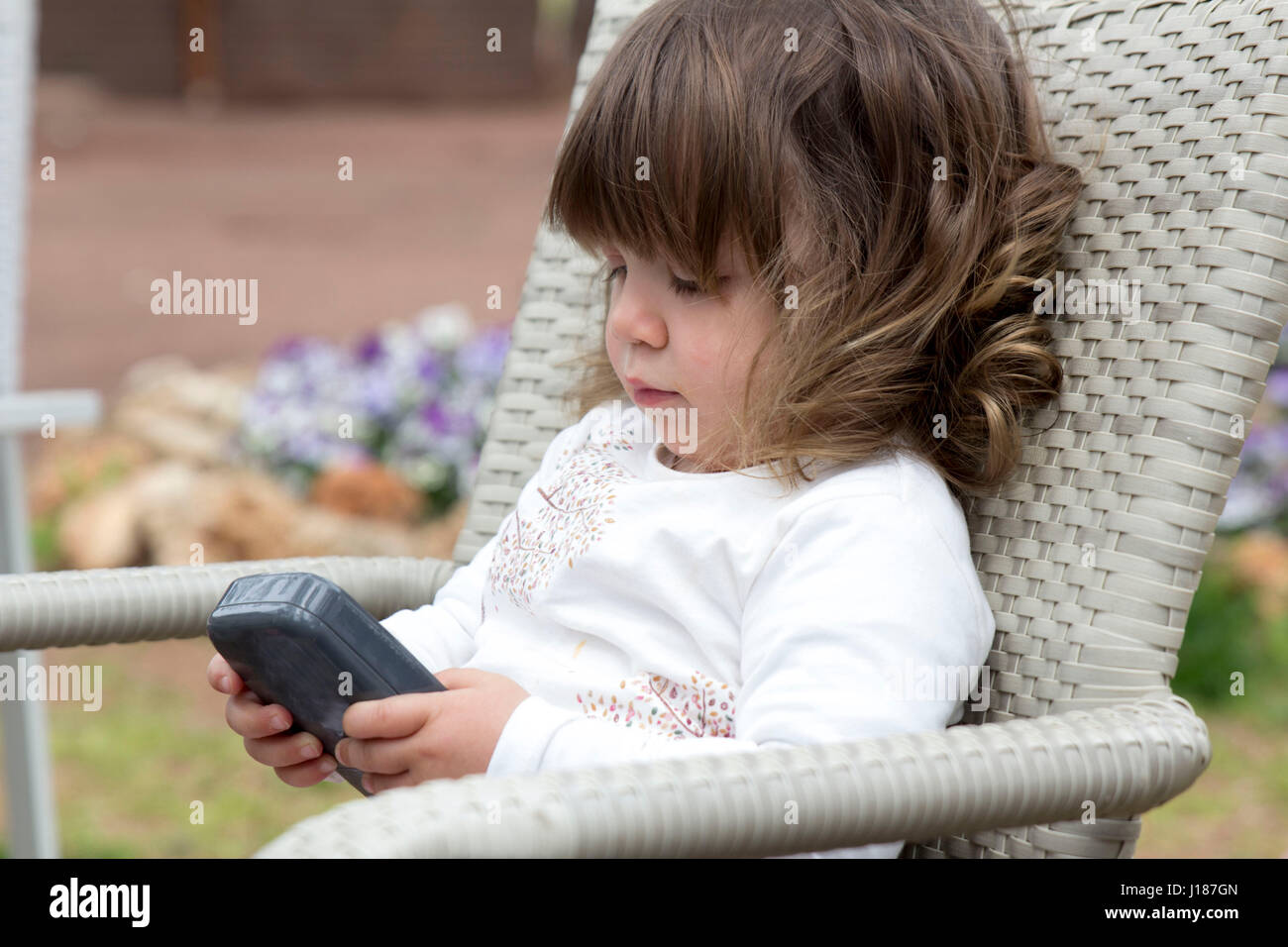 toddler girl playing with phone Stock Photo - Alamy