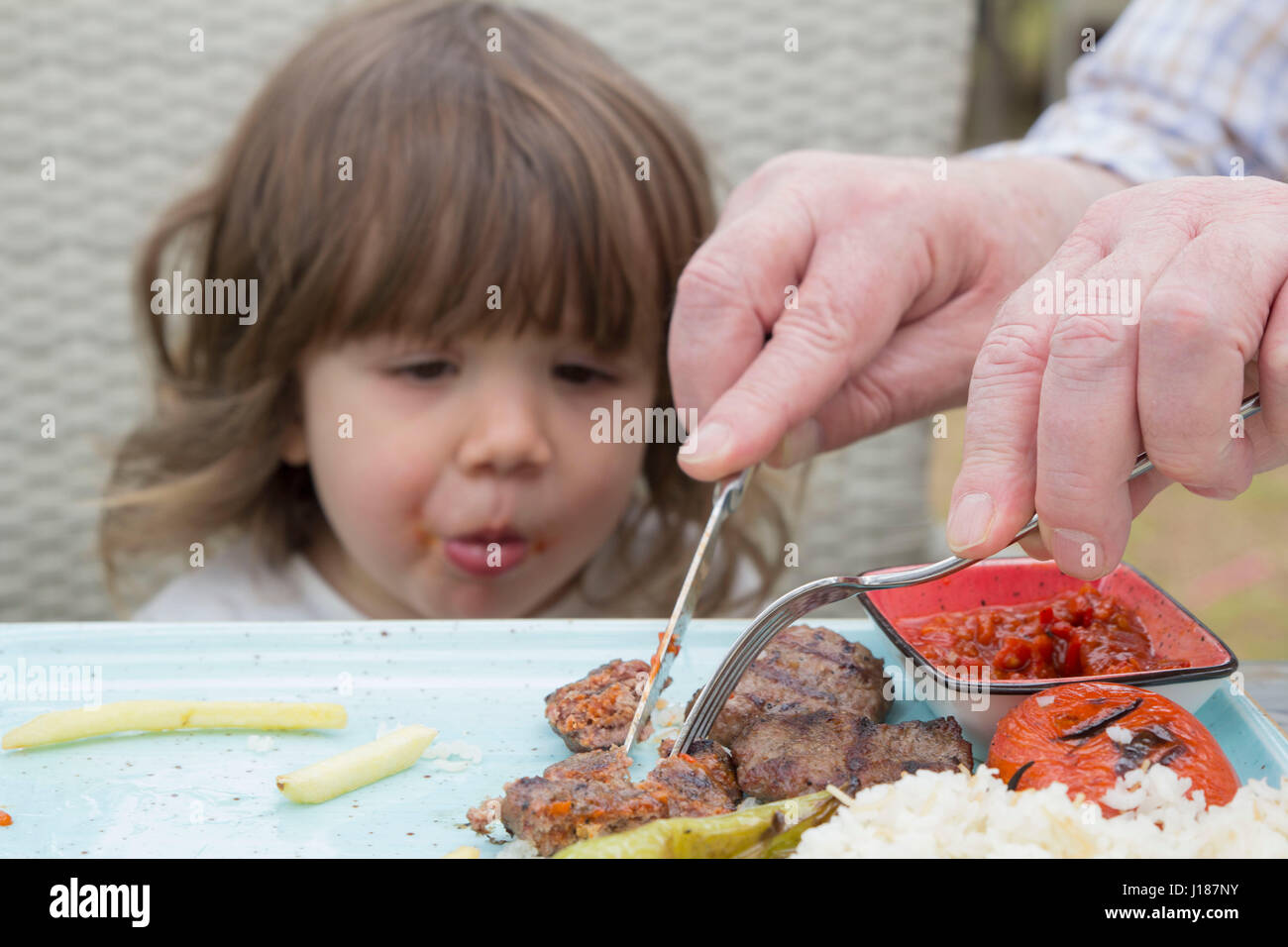 hands cutting meat child watches while eating Stock Photo - Alamy