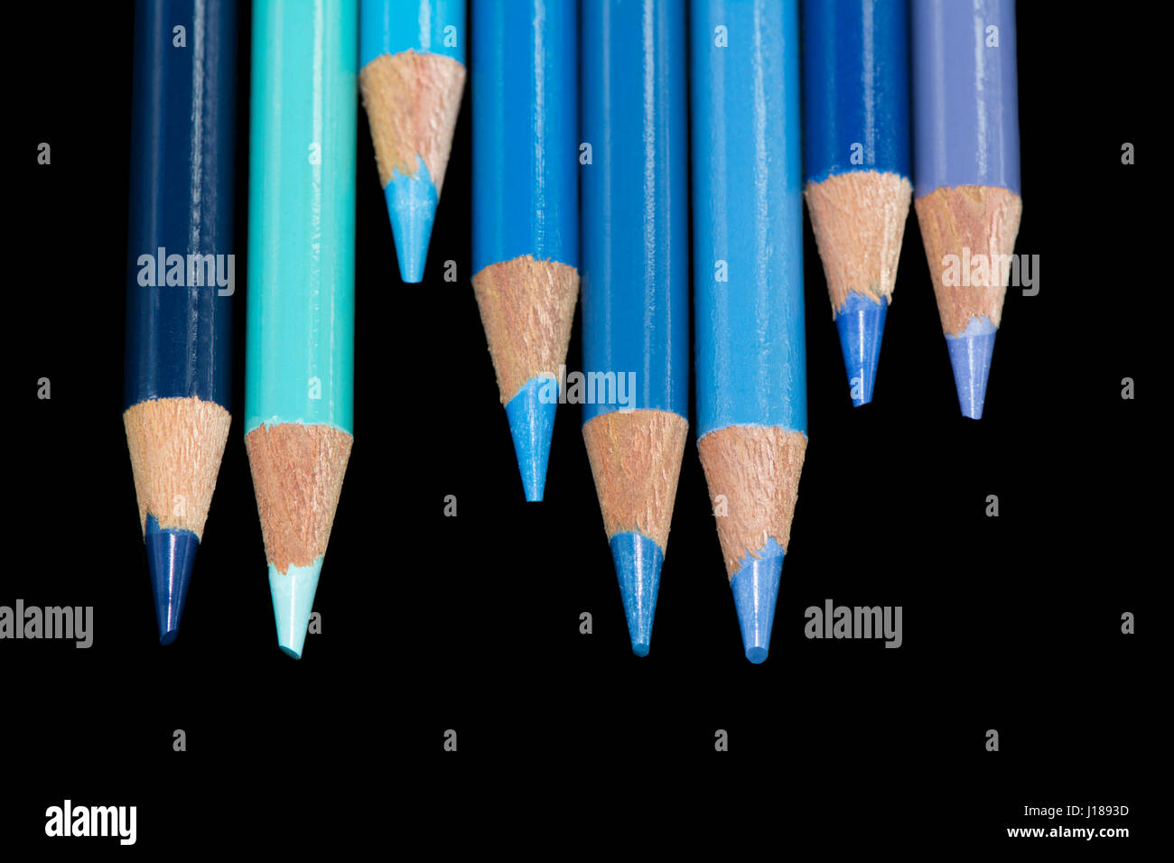 Eight blue coloured pencils lined up with staggered lengths and a dark ...