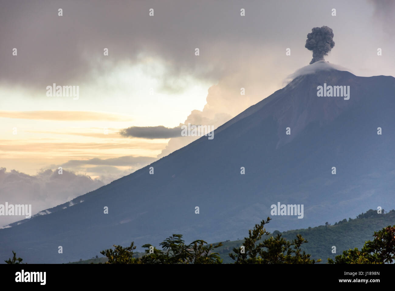 Sunset over active smoking Fuego volcano near Spanish colonial town ...