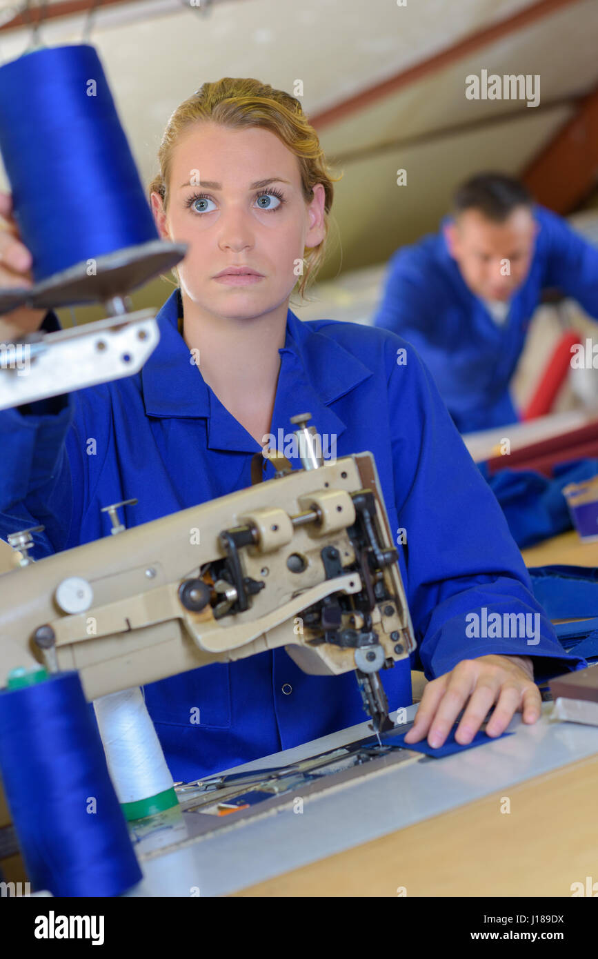 Woman adjusting thread on sewing machine Stock Photo - Alamy
