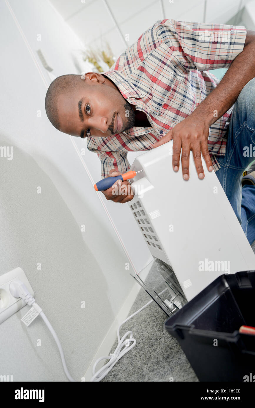 man fixing unit Stock Photo - Alamy