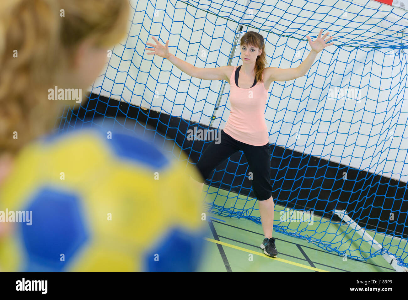 Woman defending goal in handball game Stock Photo - Alamy
