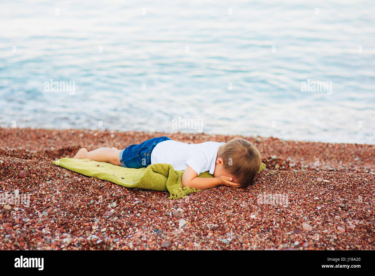 A frustrated child cries on a pebble beach Stock Photo - Alamy