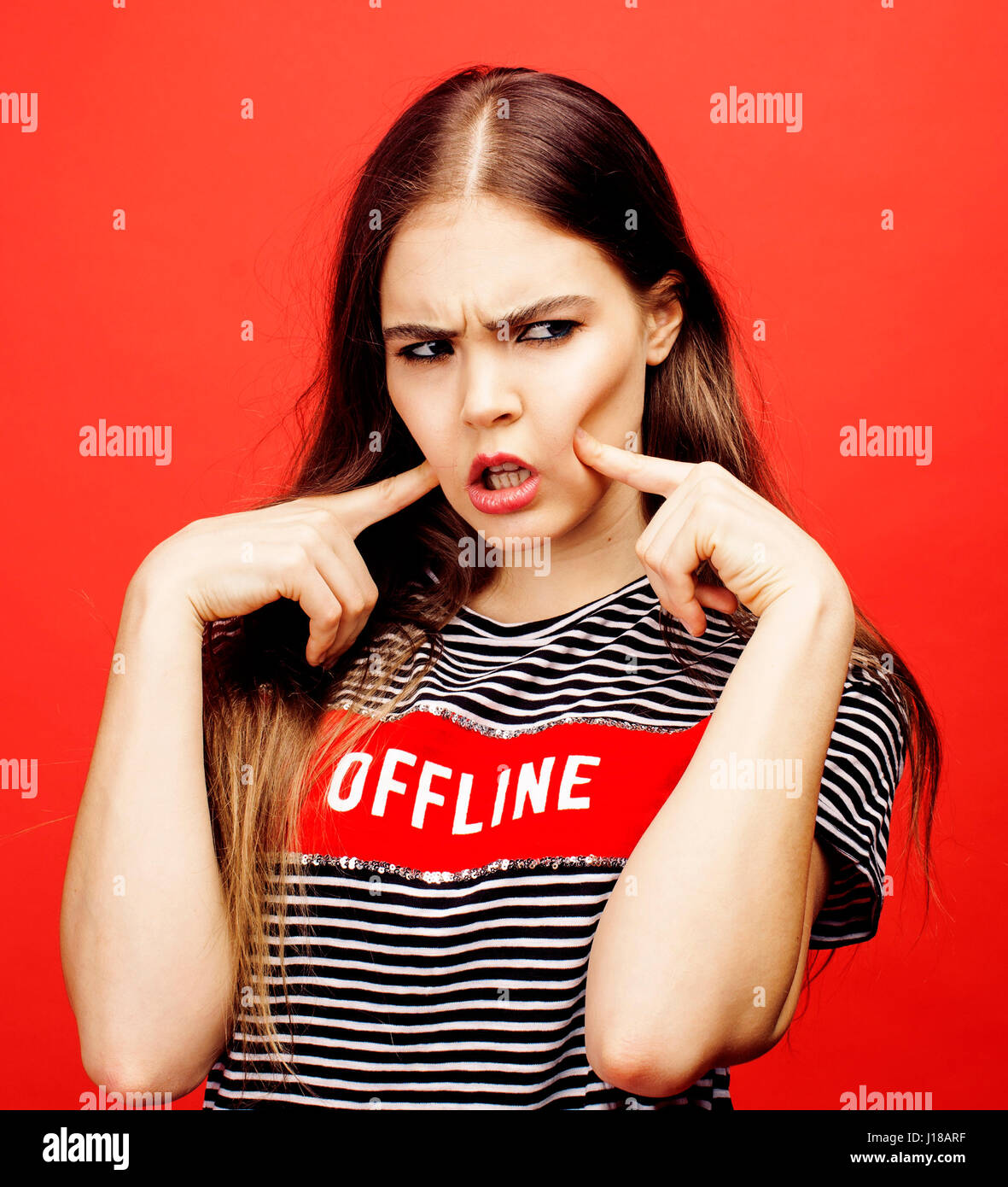 young pretty emitonal posing teenage girl on bright red background ...