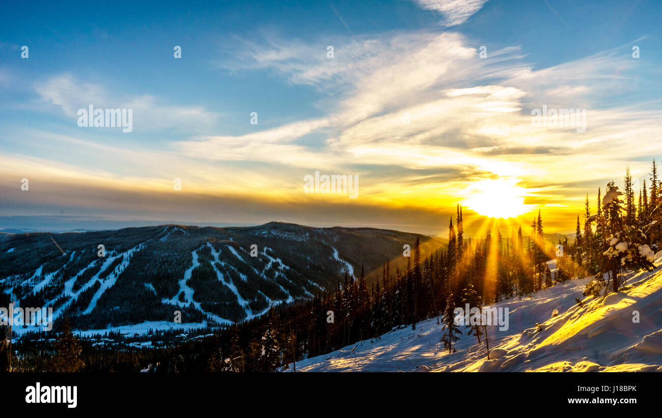 Majestic sunset with sun rays over the beautiful winter landscape of ...