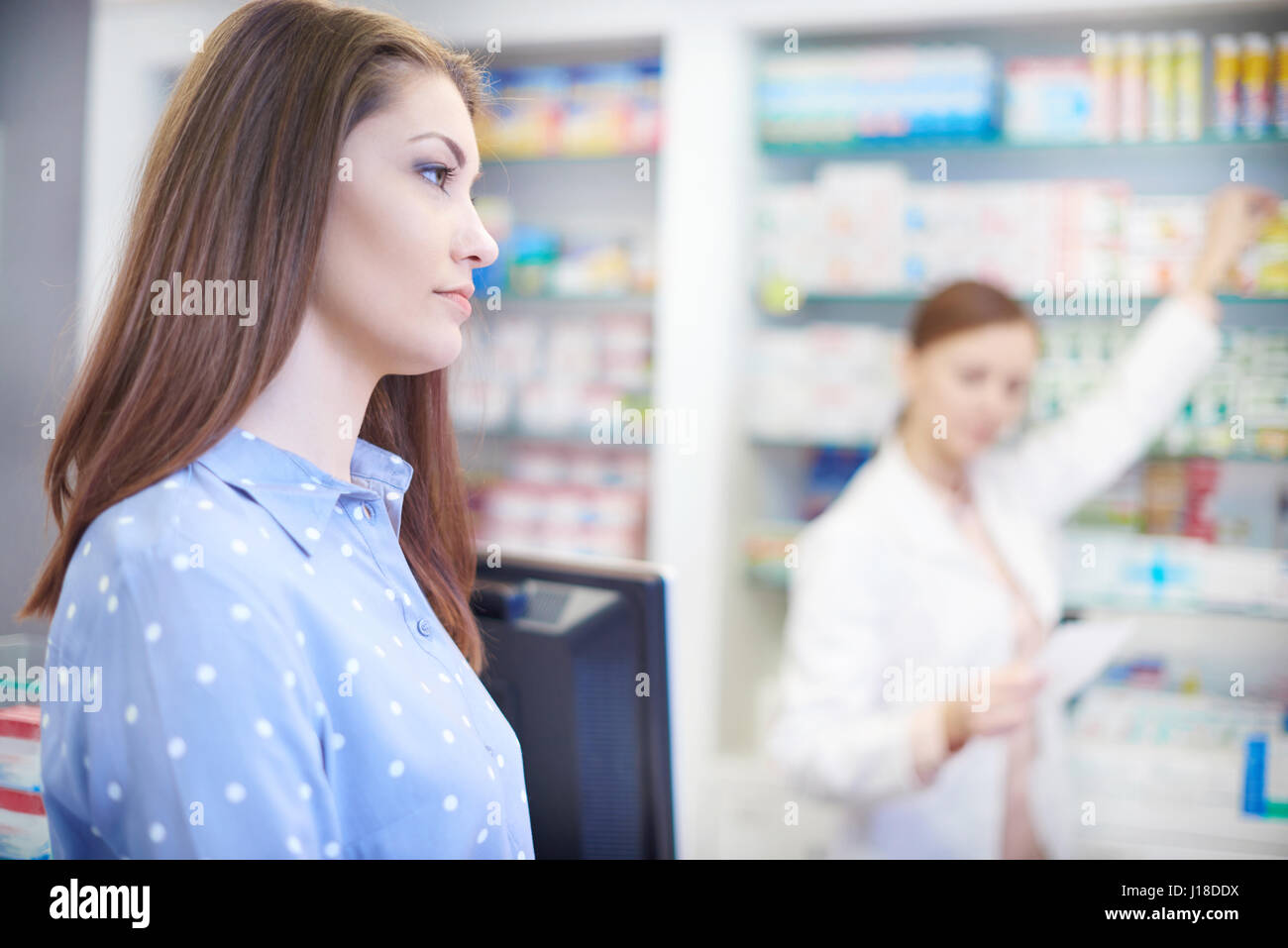 Woman waiting next to cash register Stock Photo - Alamy